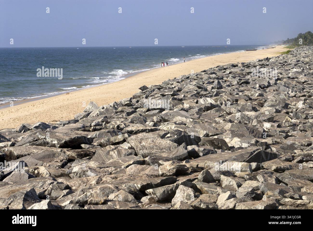 Sand and blue water of Arabian sea with pitching of rubble stone to ...