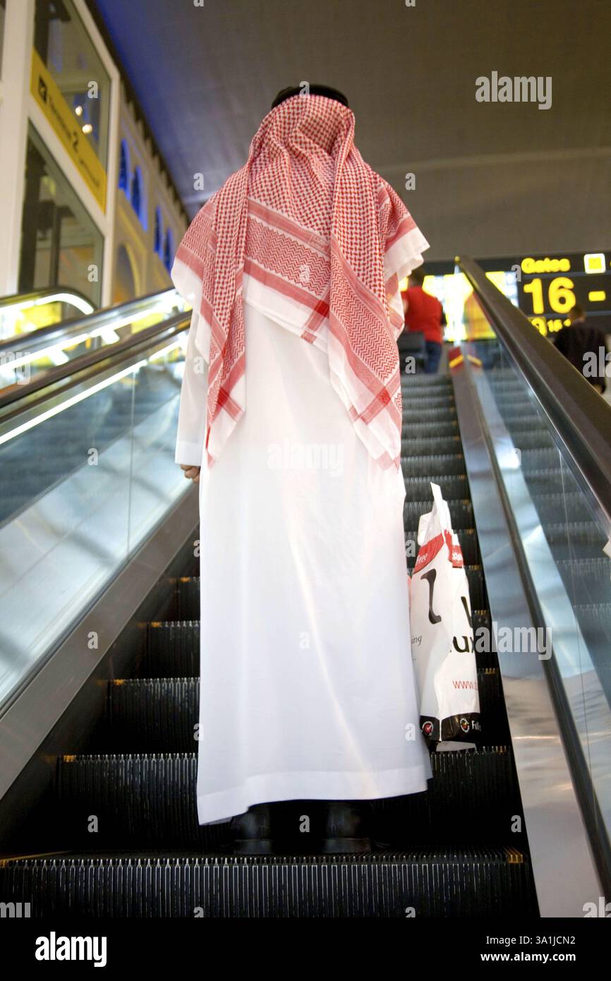 Man in traditional white Arabian dressed on automatic ladder, Dubai ...