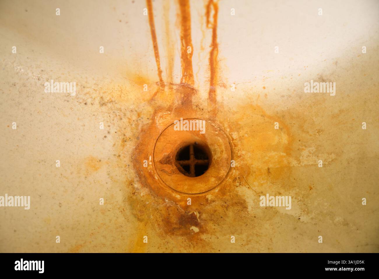 Close-up of a rusty and stained sink drain with corrosion and mineral ...