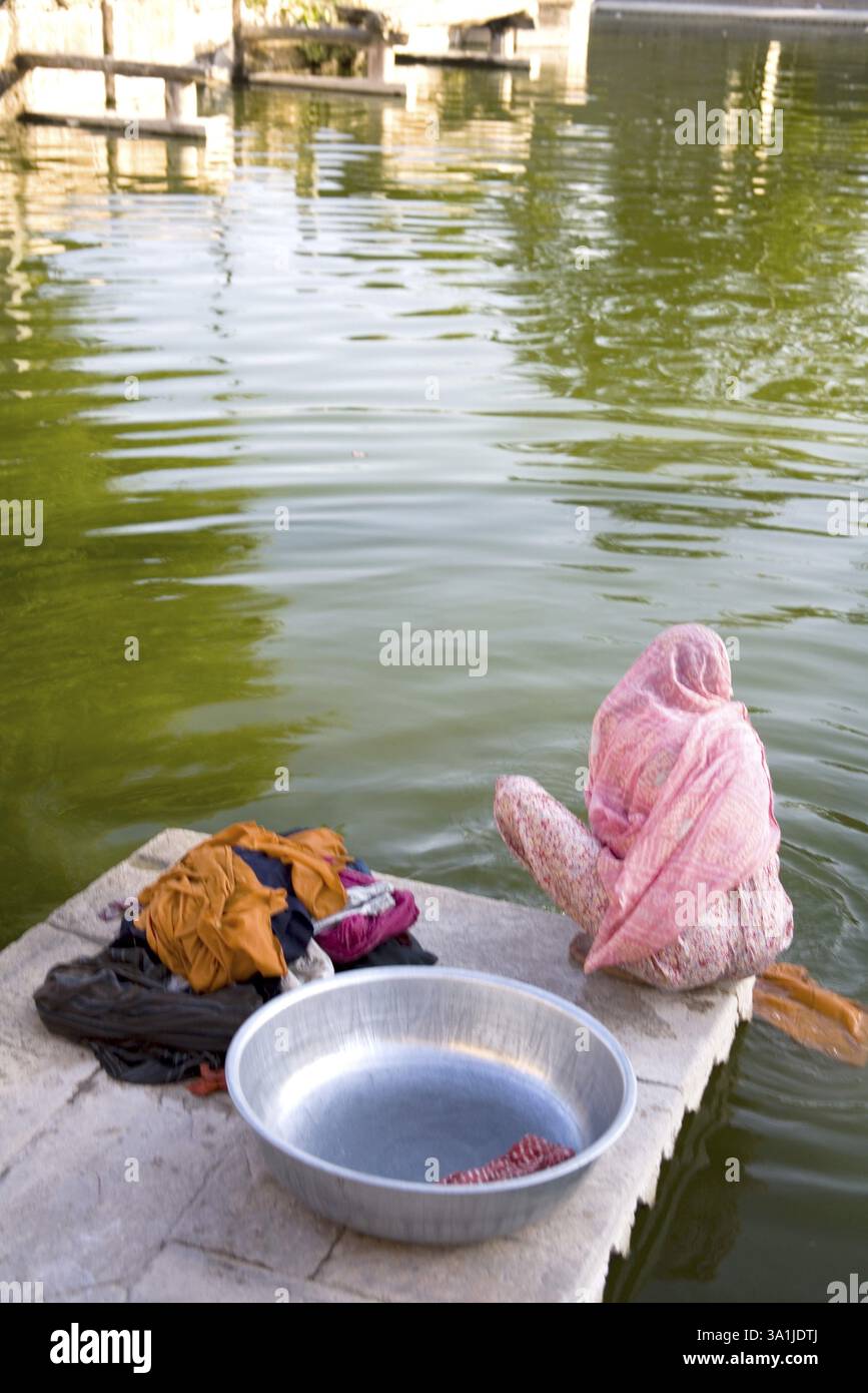 Woman washing cloths on pond water system in semi urban village Dilwara ...