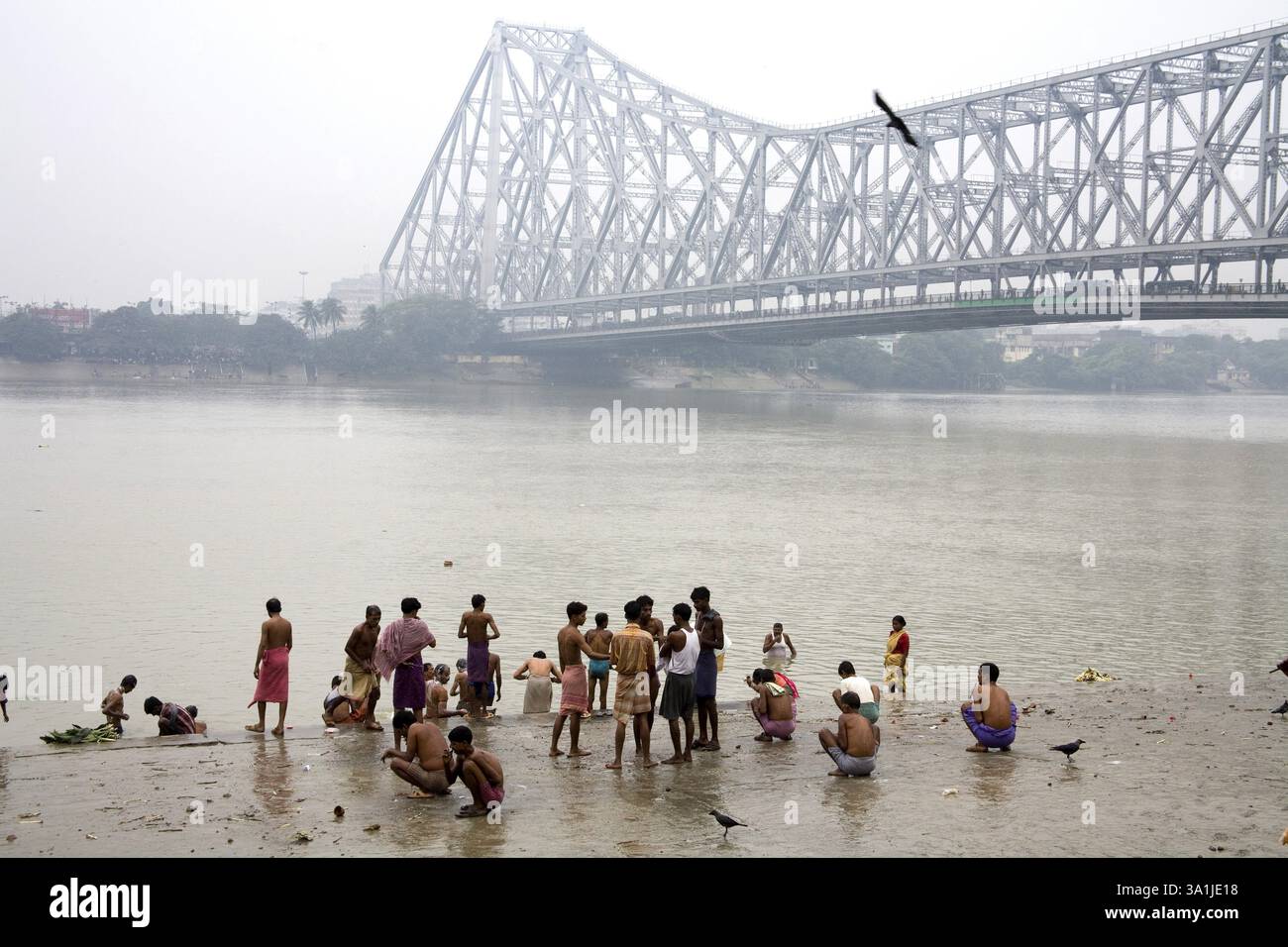 Activities on Babu ghat, Howrah bridge over Hooghly river in background ...