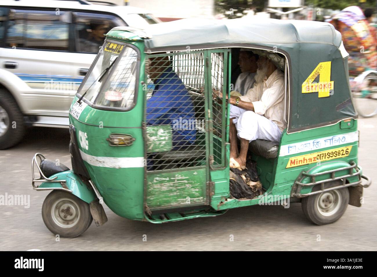 Street scene, passengers sitting in green color auto rickshaw, Dhaka ...