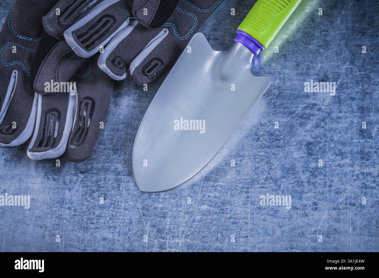 Metal hand spade safety gloves on metallic background agriculture ...
