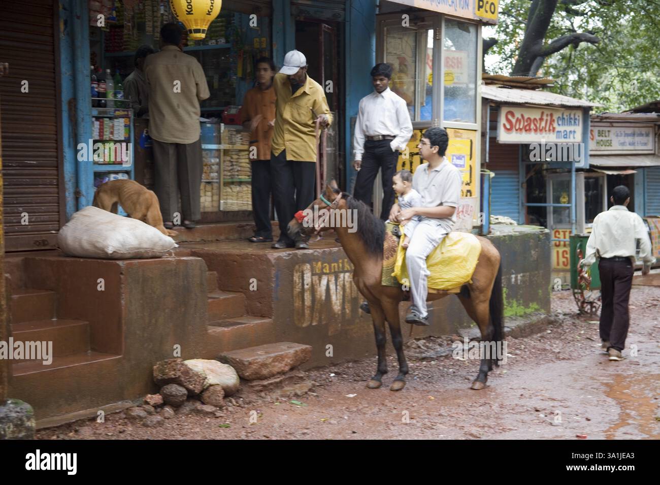 Father and son riding on horse doing shopping in market Matheran ...