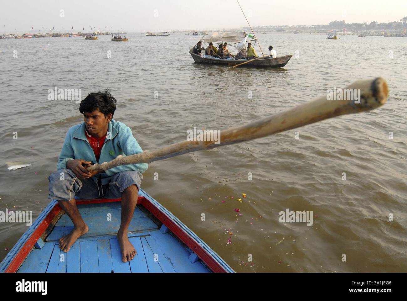 Sailor sit in his boat with long bamboo stick to ferry devotees at the ...
