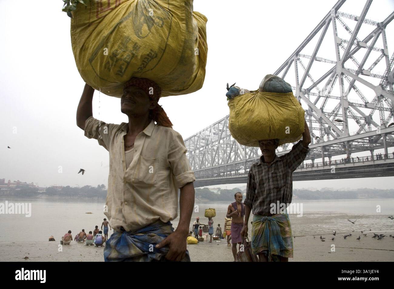 Men carrying load on head Howrah bridge over Hooghly river in ...