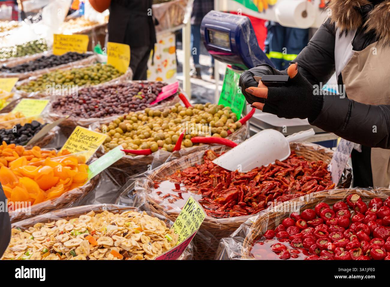 Outdoor market stall with baskets filled with olives dried fruits and ...