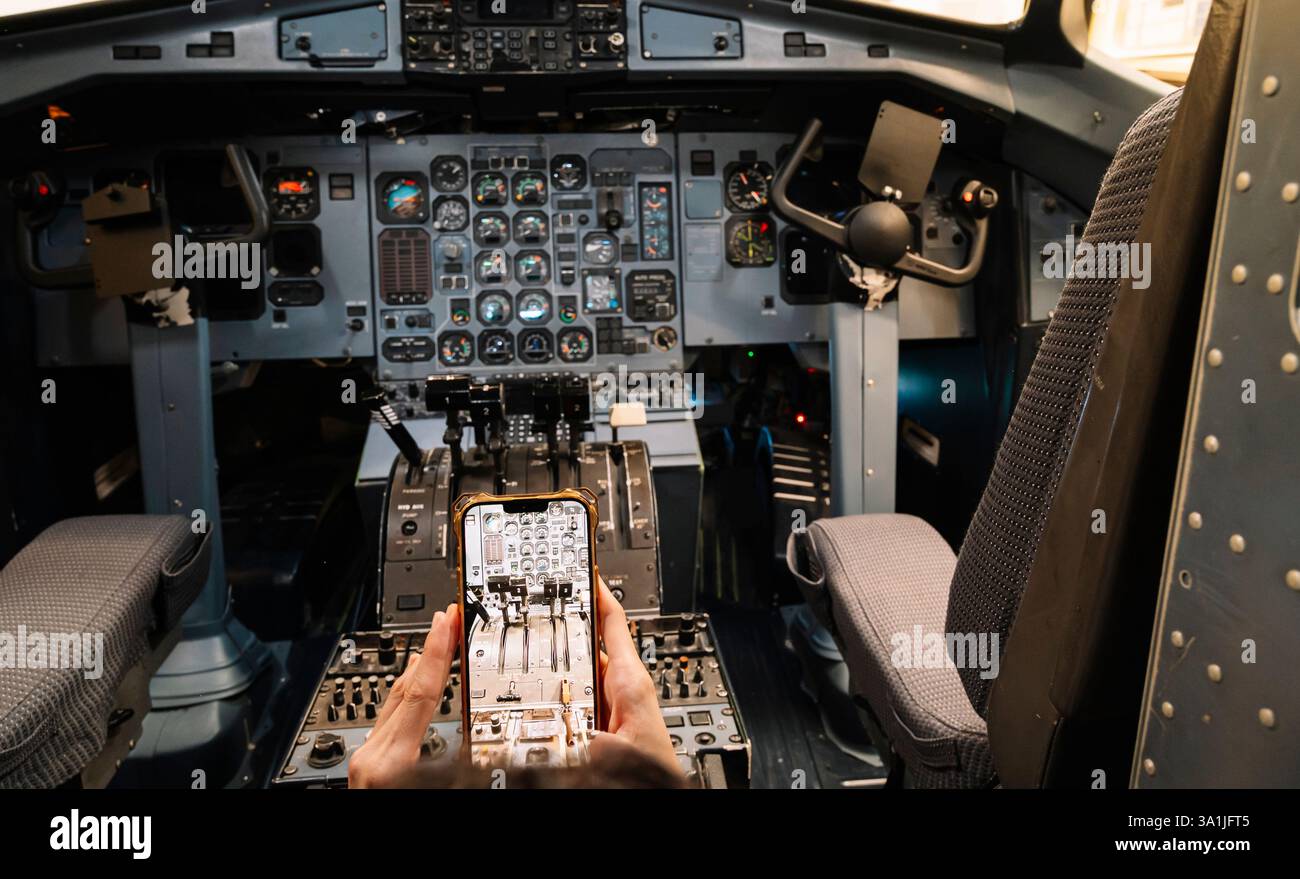 A person is holding a cell phone in the cockpit of an airplane Stock ...