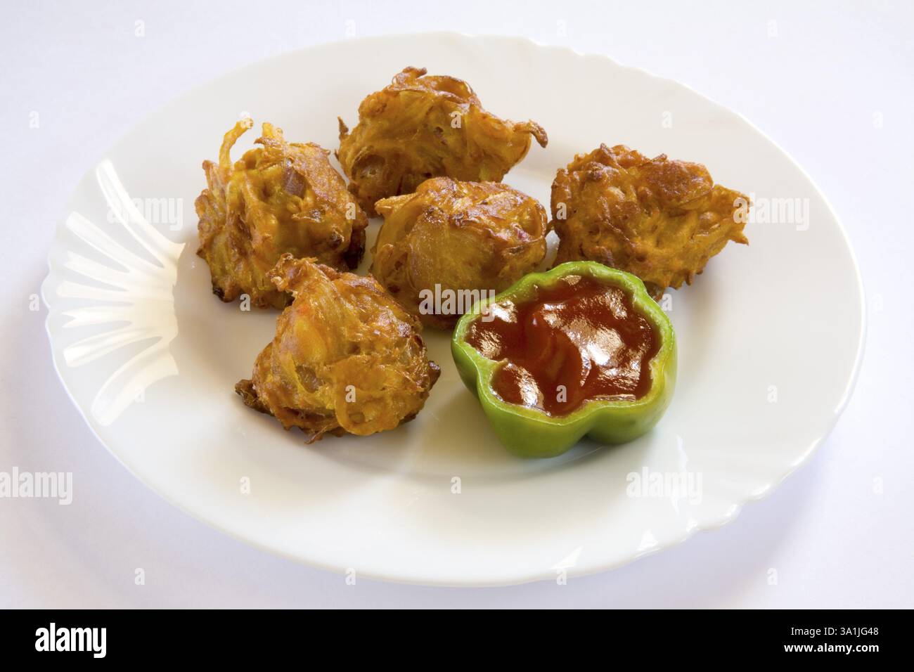 Indian fast food fried kanda bhaji served with tomato ketchup in plate ...
