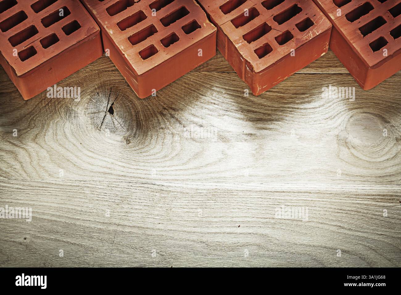 Red bricks on wooden board top view bricklaying concept Stock Photo - Alamy