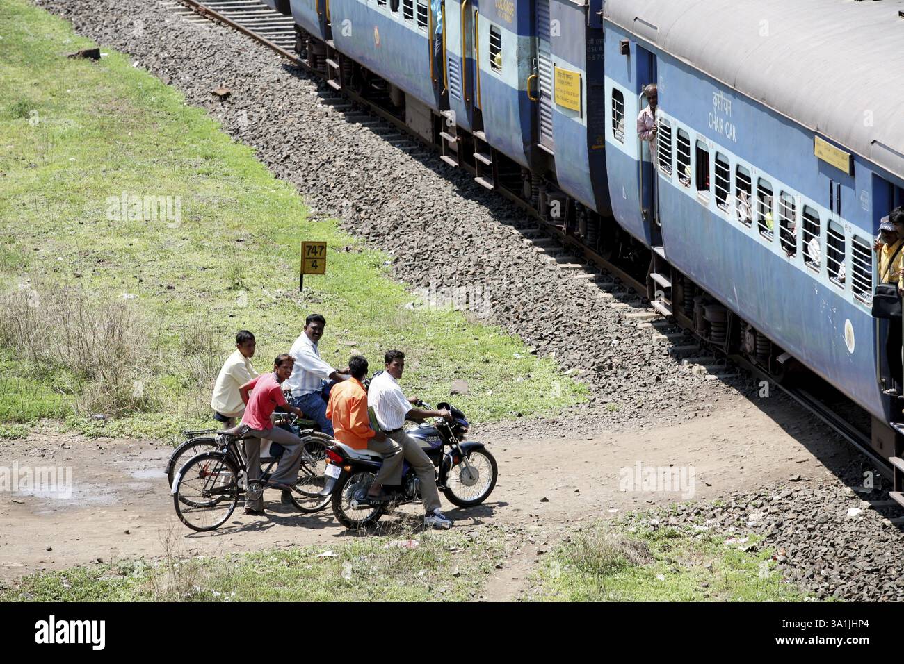People waiting for the mail train to pass so that they can cross the ...