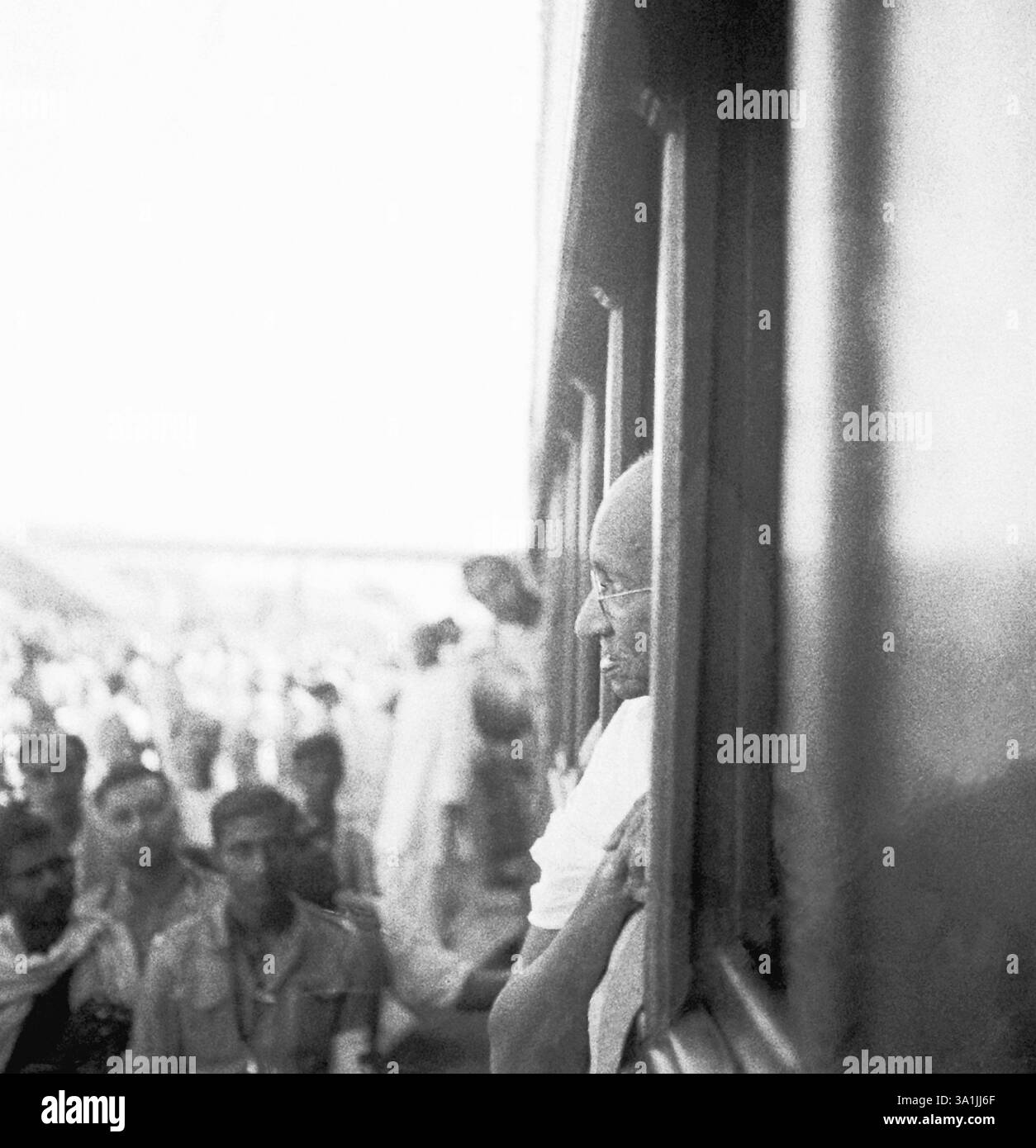 Mahatma Gandhi, looking through a train window to the public at a ...