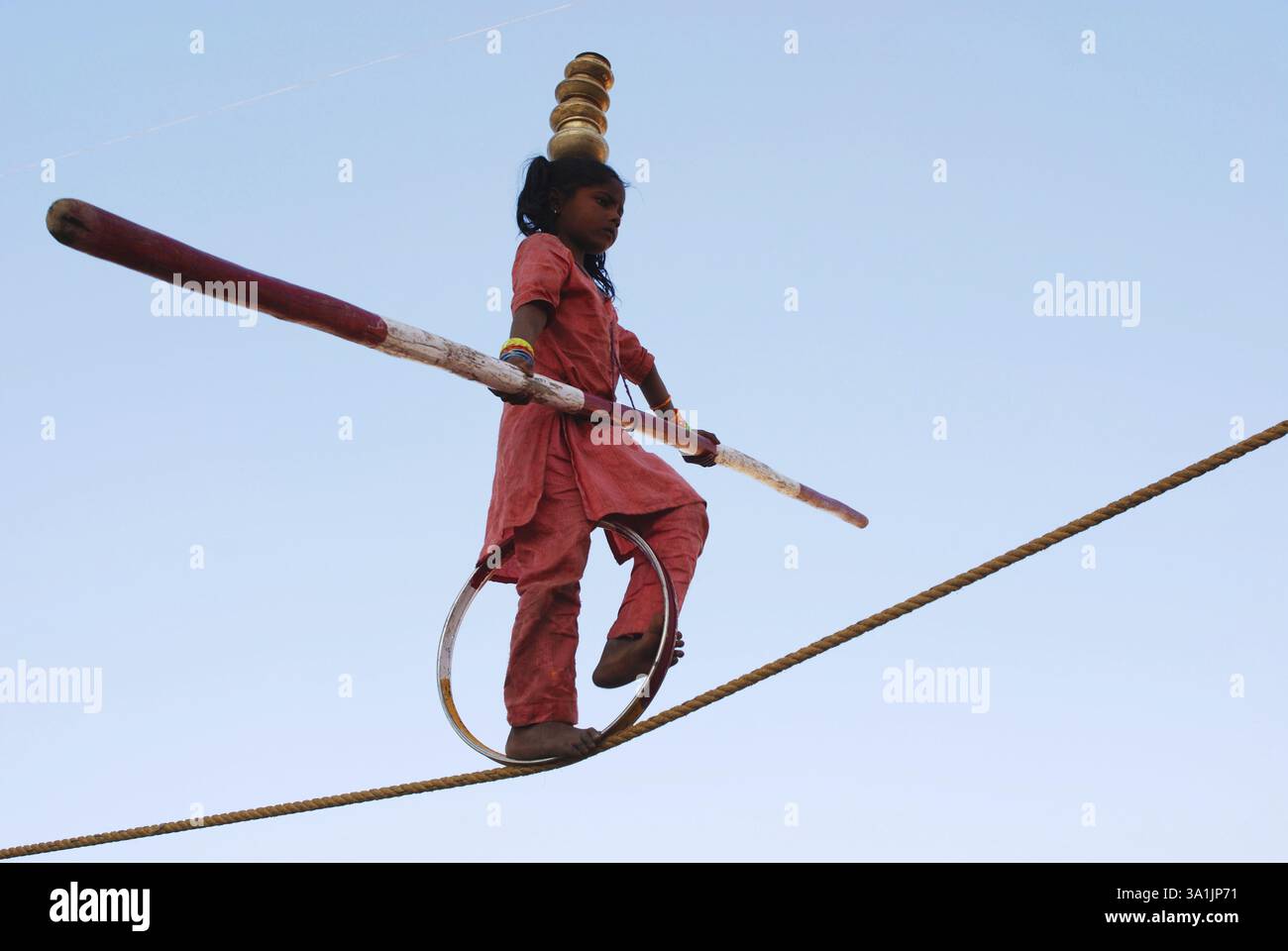 Girl balancing on rope holding bamboo in hand, Pushkar fair, Rajasthan ...