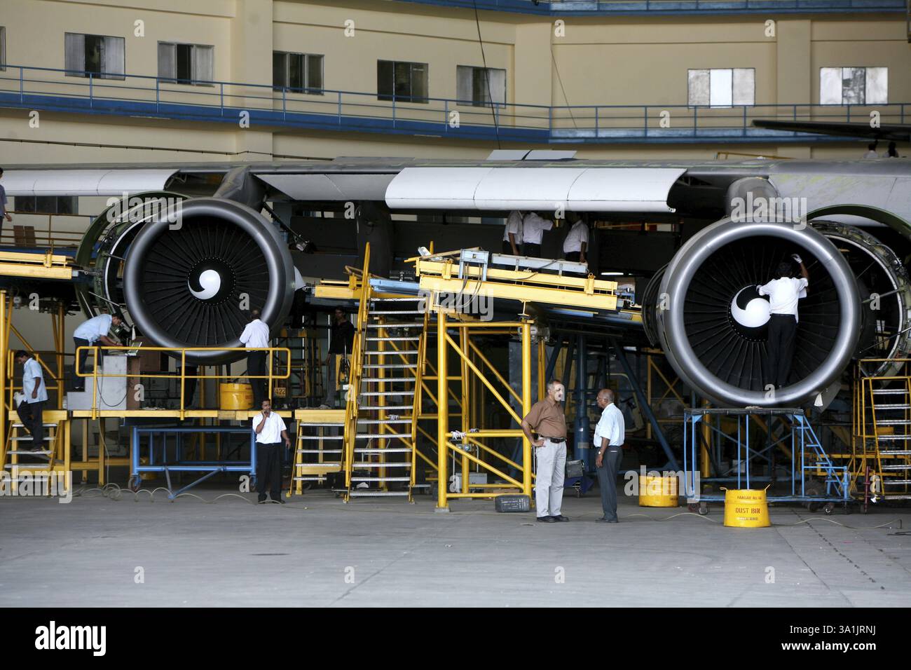 A group of engineers working on Boeing 747-400 parked for maintenance ...
