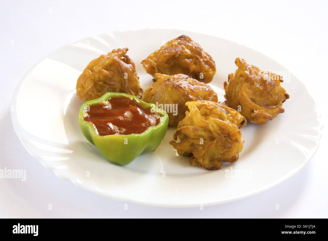 Indian fast food fried kanda bhaji served with tomato ketchup in plate ...