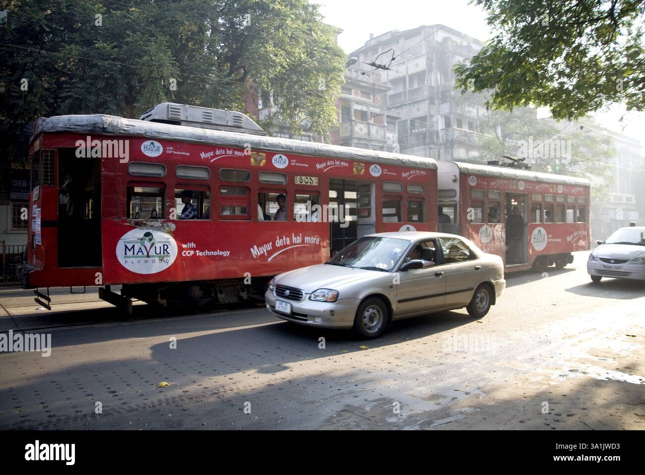 Tram in old way of commuting service with luxury cars on road, Calcutta ...