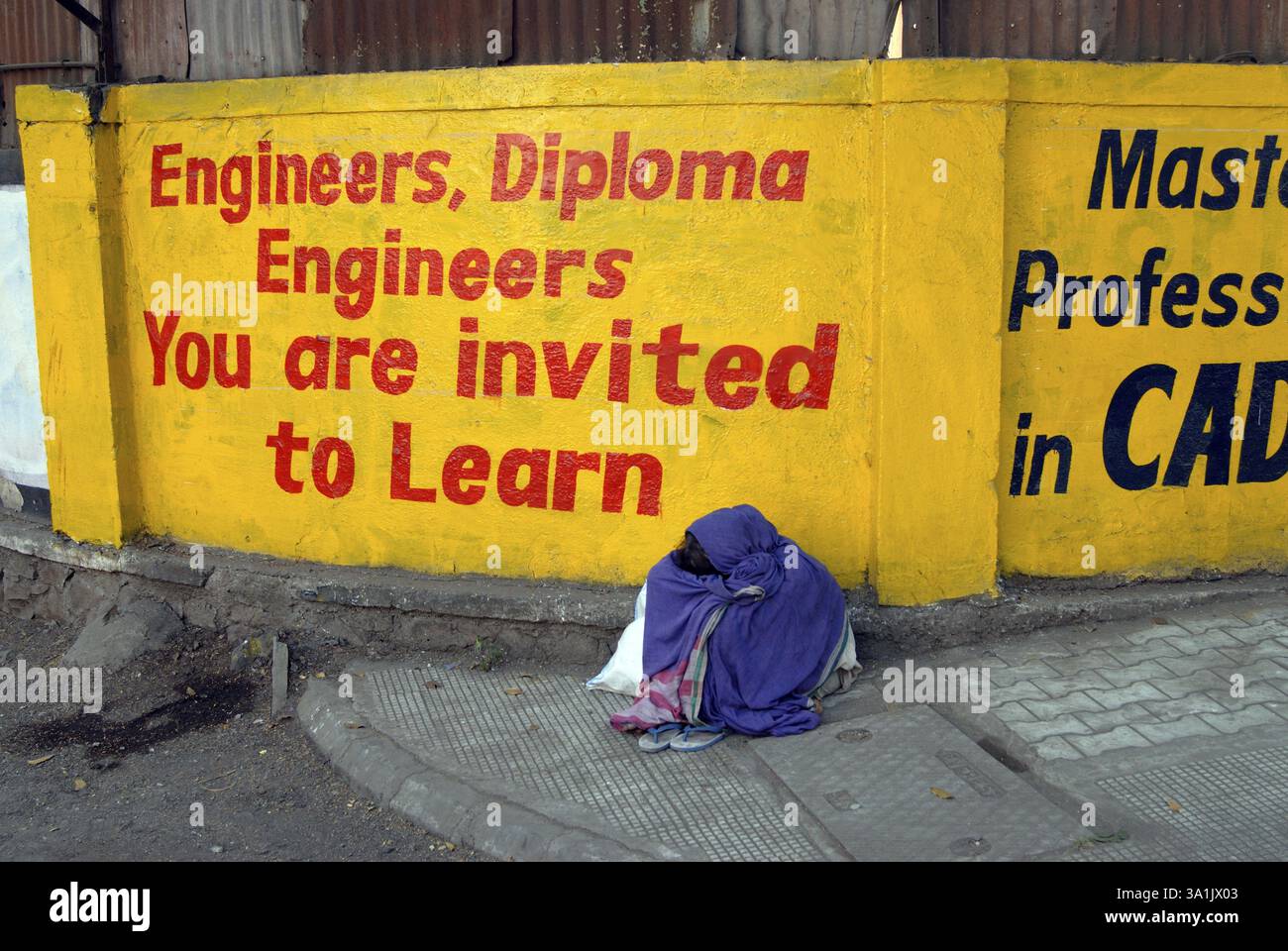A poster and a beggar at Pune railway station, Maharashtra, India, Asia ...