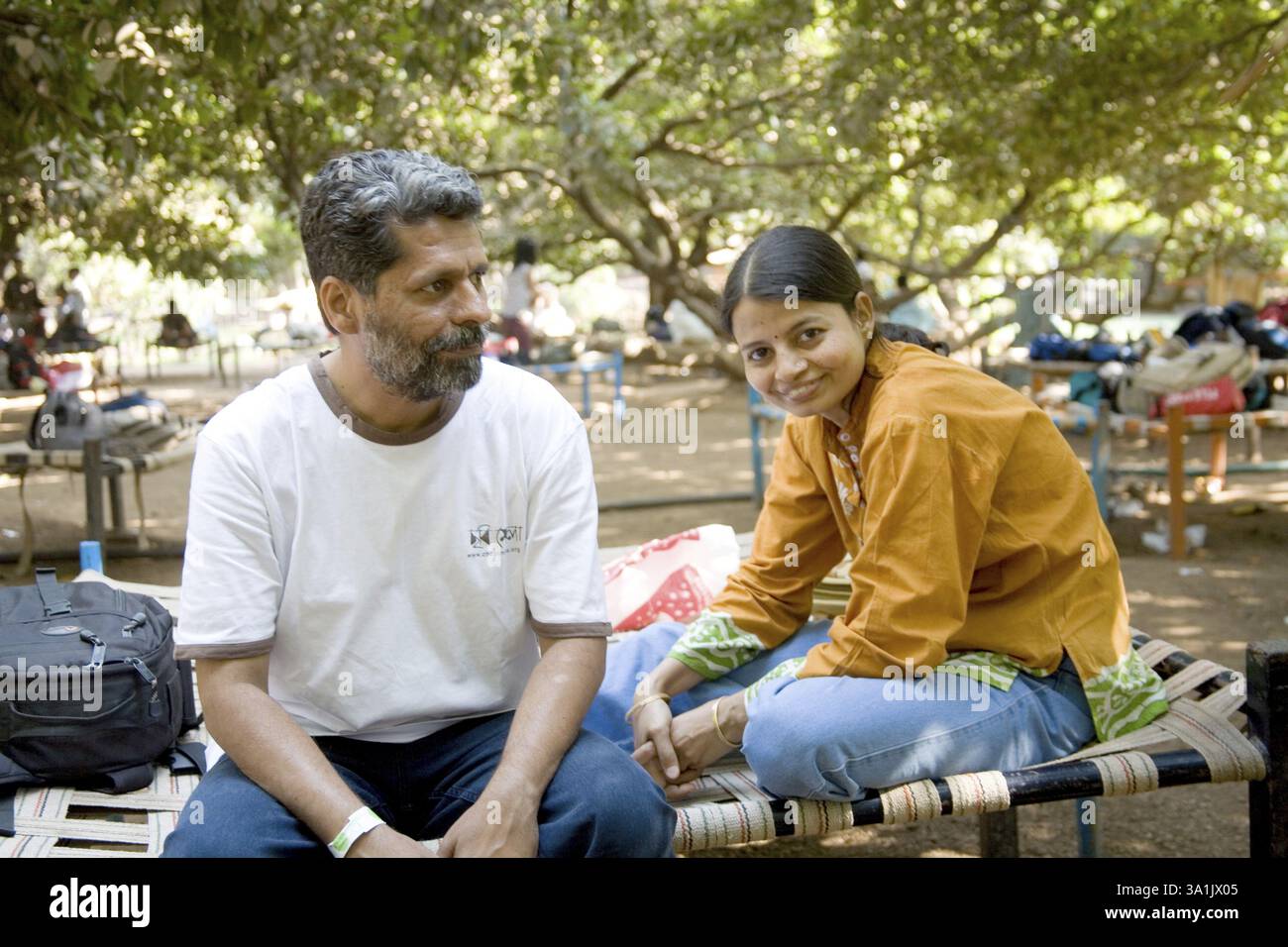 South Asian Indian man and woman sitting on rural cot in Amusement park ...