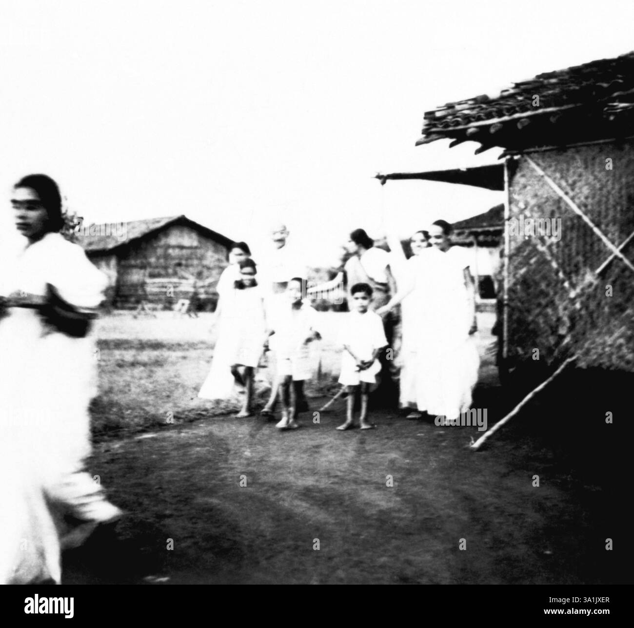 Mahatma Gandhi and others walking on the campus of Sevagram Ashram ...