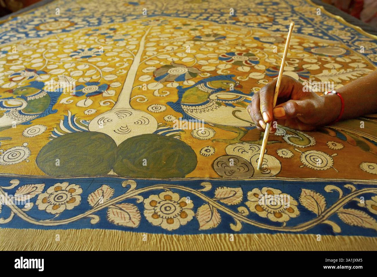 Kalamkari textile craft Hand application of vegetable dye with a wooden ...