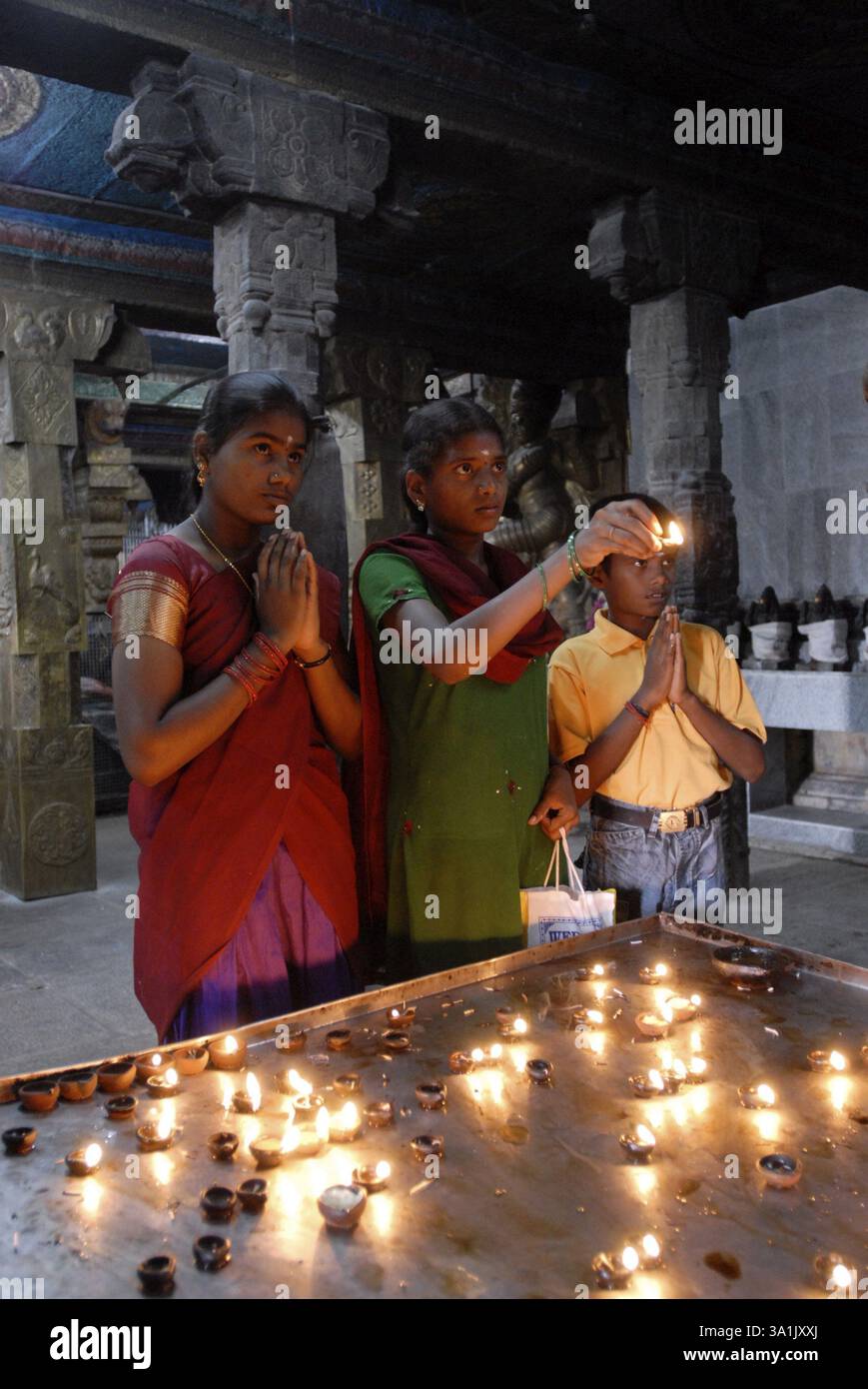 Women worshipping by lighting oil lamps in Swaminatha Swami temple ...
