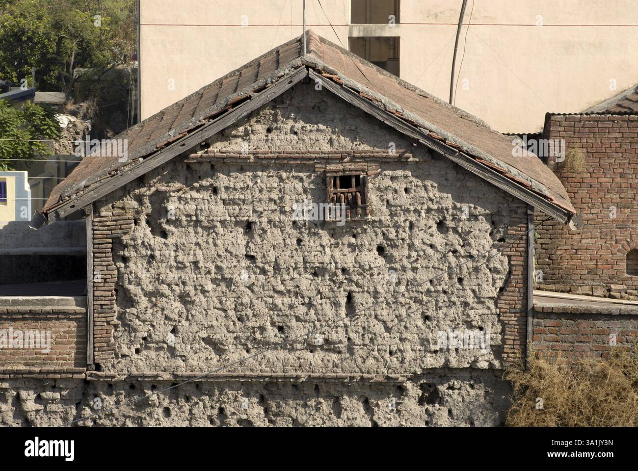 Poorly plastered external wall and window of old Mangalore tiled roof ...