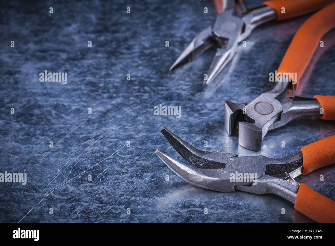 Insulated electric nippers gripping tongs on scratched metallic ...