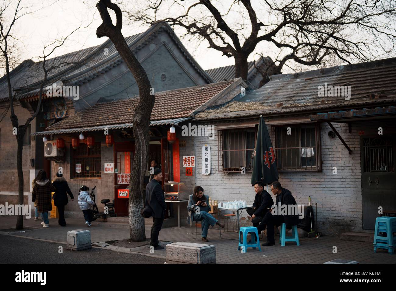 Residents sit outside their houses in the evening in downtown Beijing ...