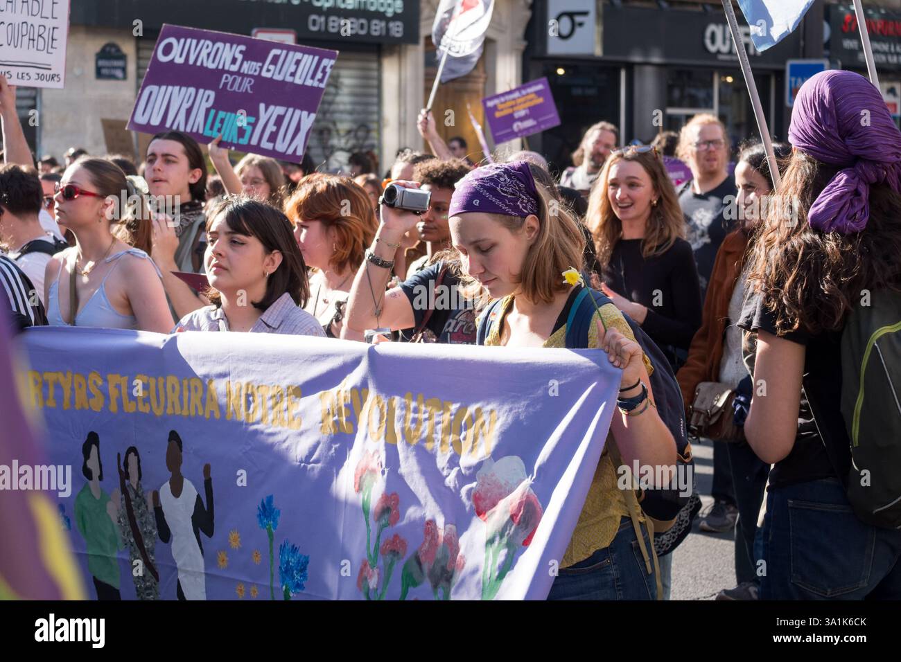 Paris, France, 8th March, 2025. Women march together, holding banners and signs during ...