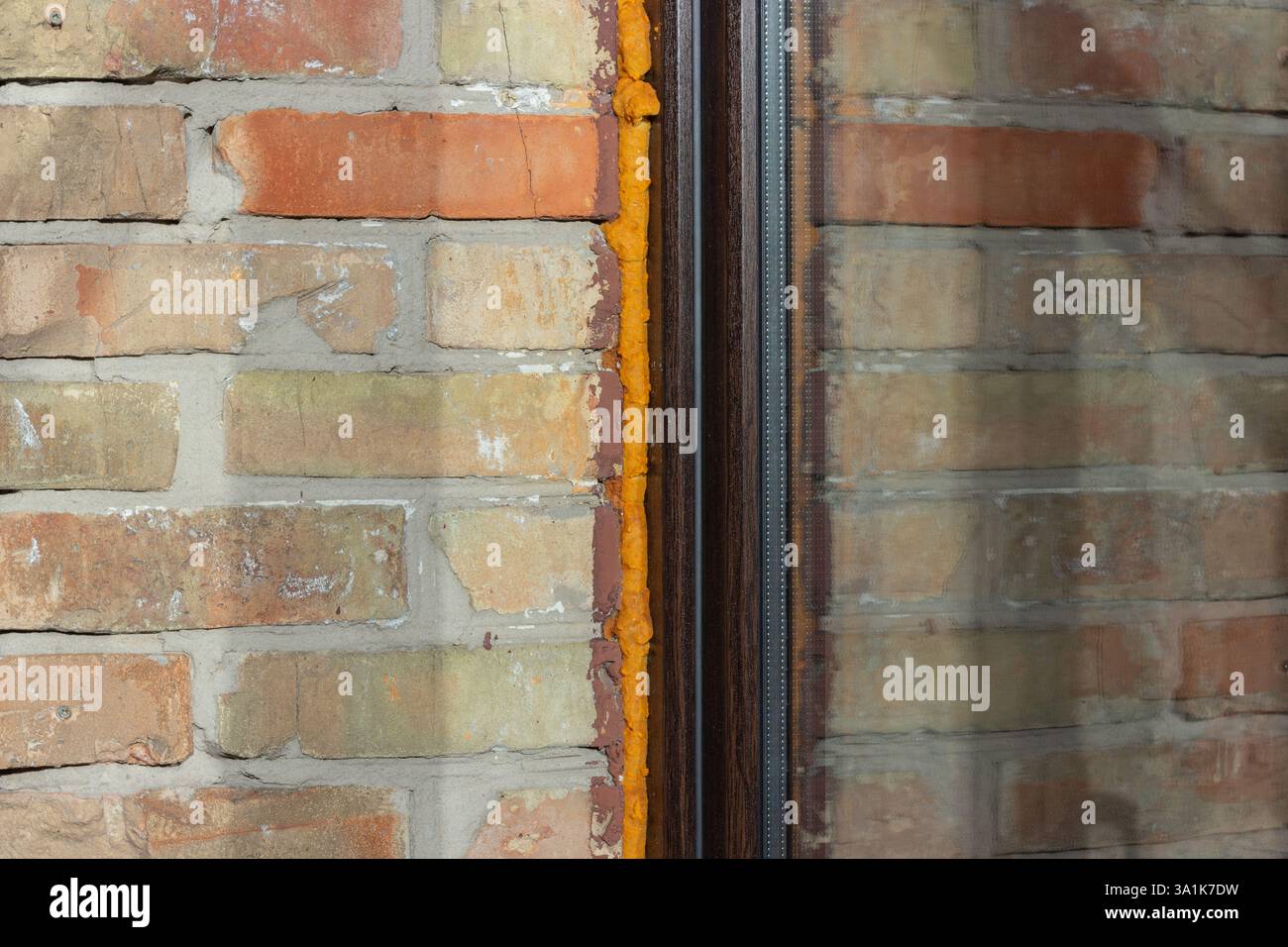 Close-up of the seam between a window and brick wall, filled with foam ...