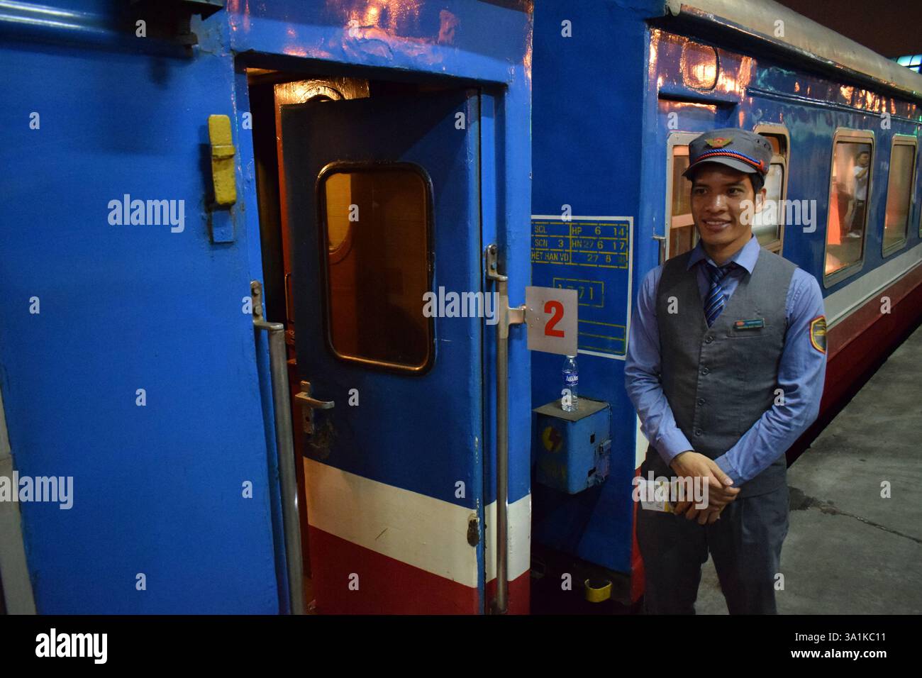 A train employee stands in front of a classic Vietnamese train in Hanoi ...