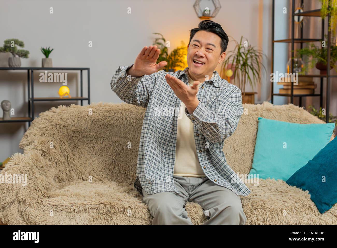 Cheerful happy rich Asian man showing wasting, throwing money around ...