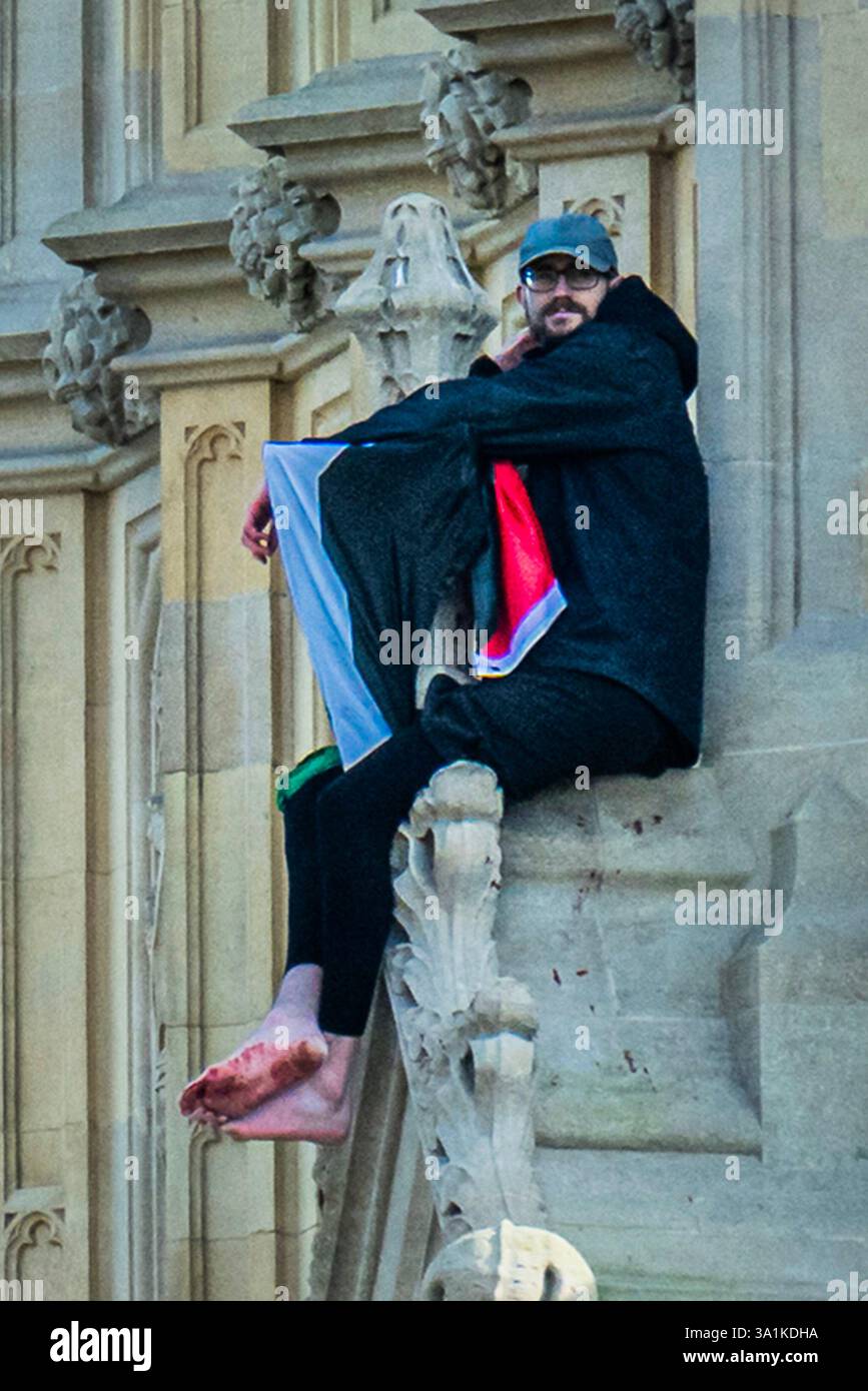 London, UK. 8th Mar, 2025. A pro Palestine man climbs a little way up ...