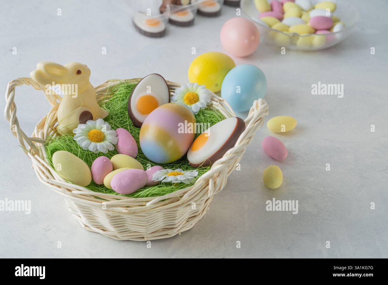 Spring easter basket preparation. Easter sweets and pastel colored eggs ...