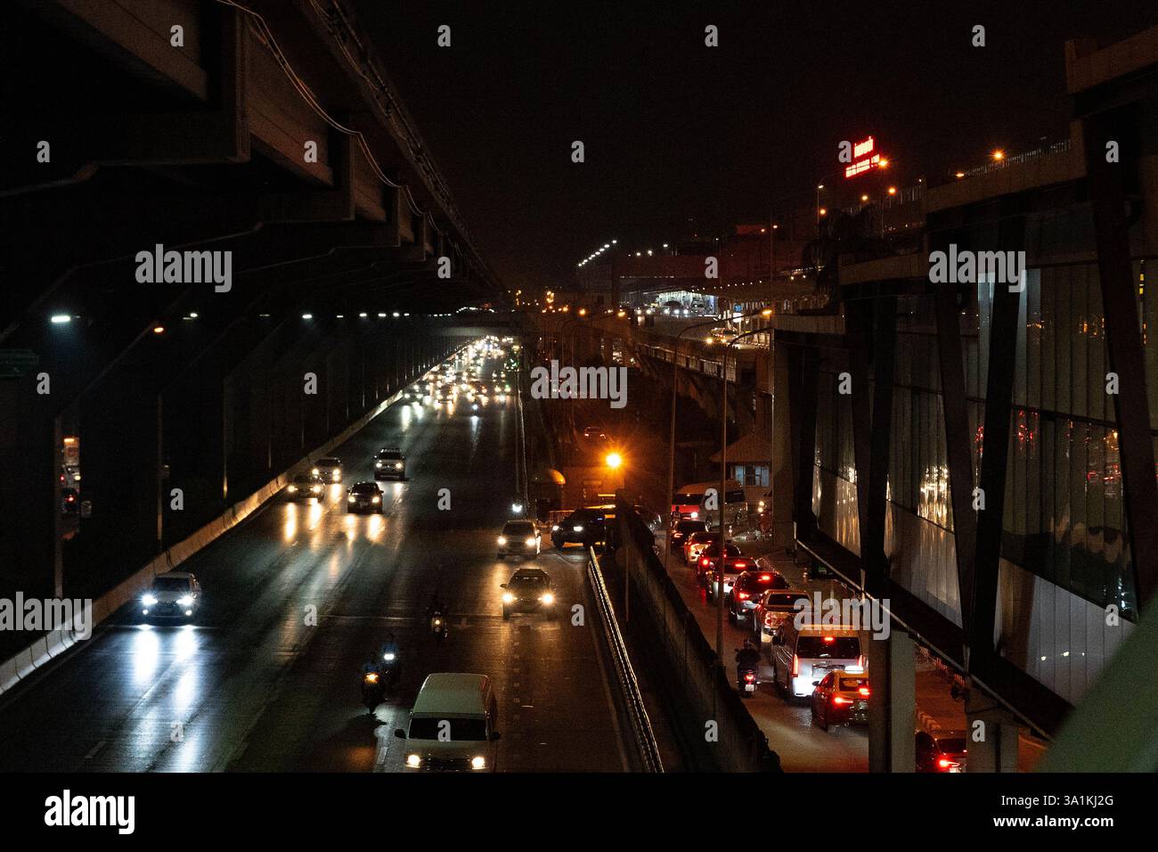 Vehicles navigate the busy highway, their headlights creating a stream ...