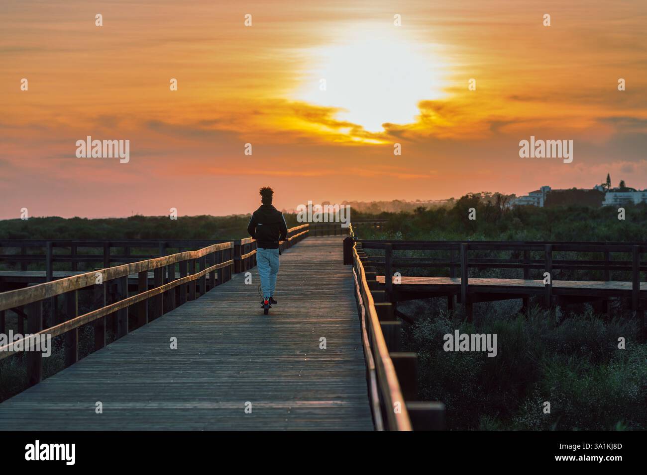 Manta Rota, Portugal, February 14, 2025. Silhouetted figure glides on a ...