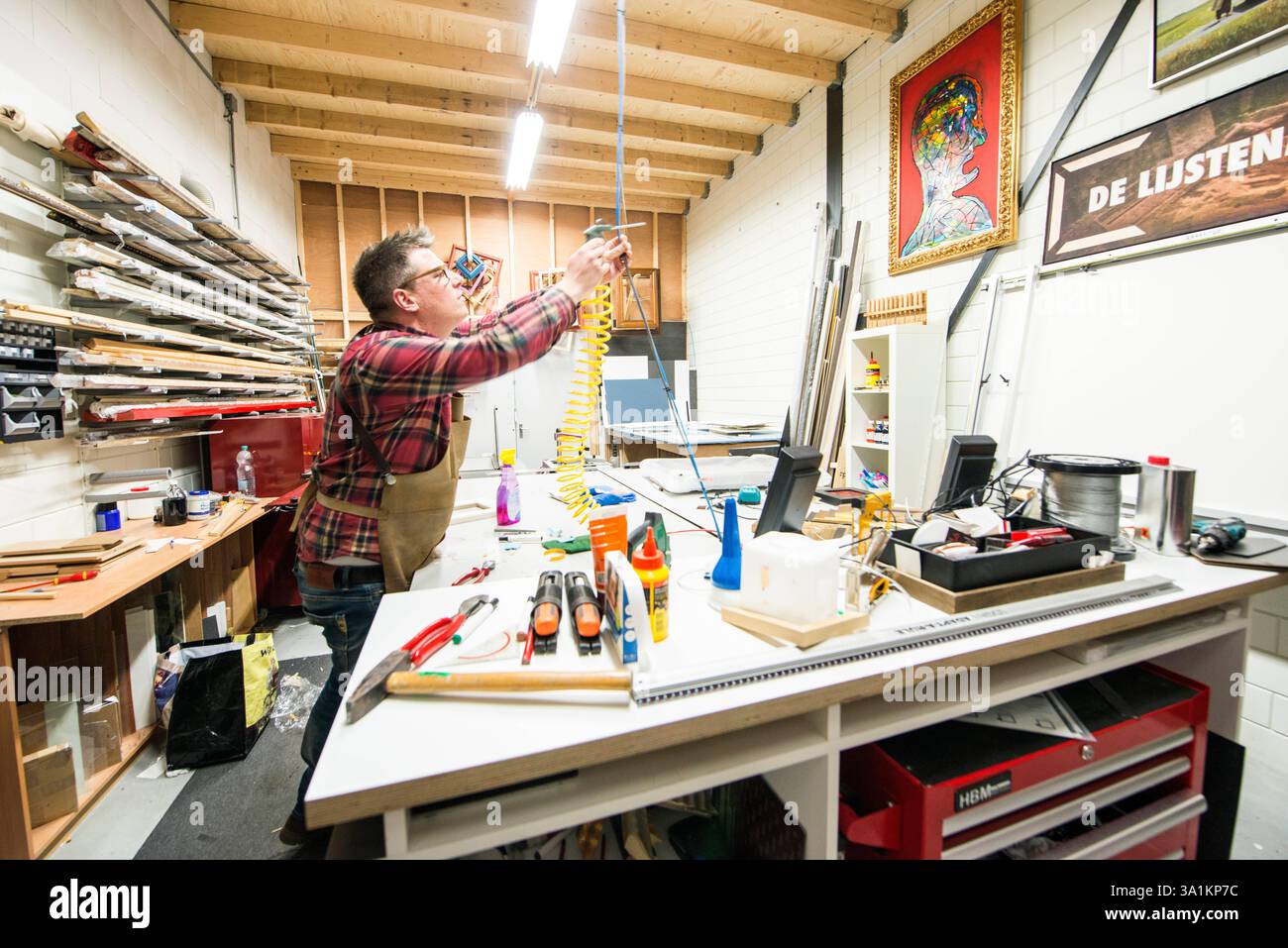 Framemaker inside his workshop Goirle, Netherlands. Mid adult male craftsman and picture ...