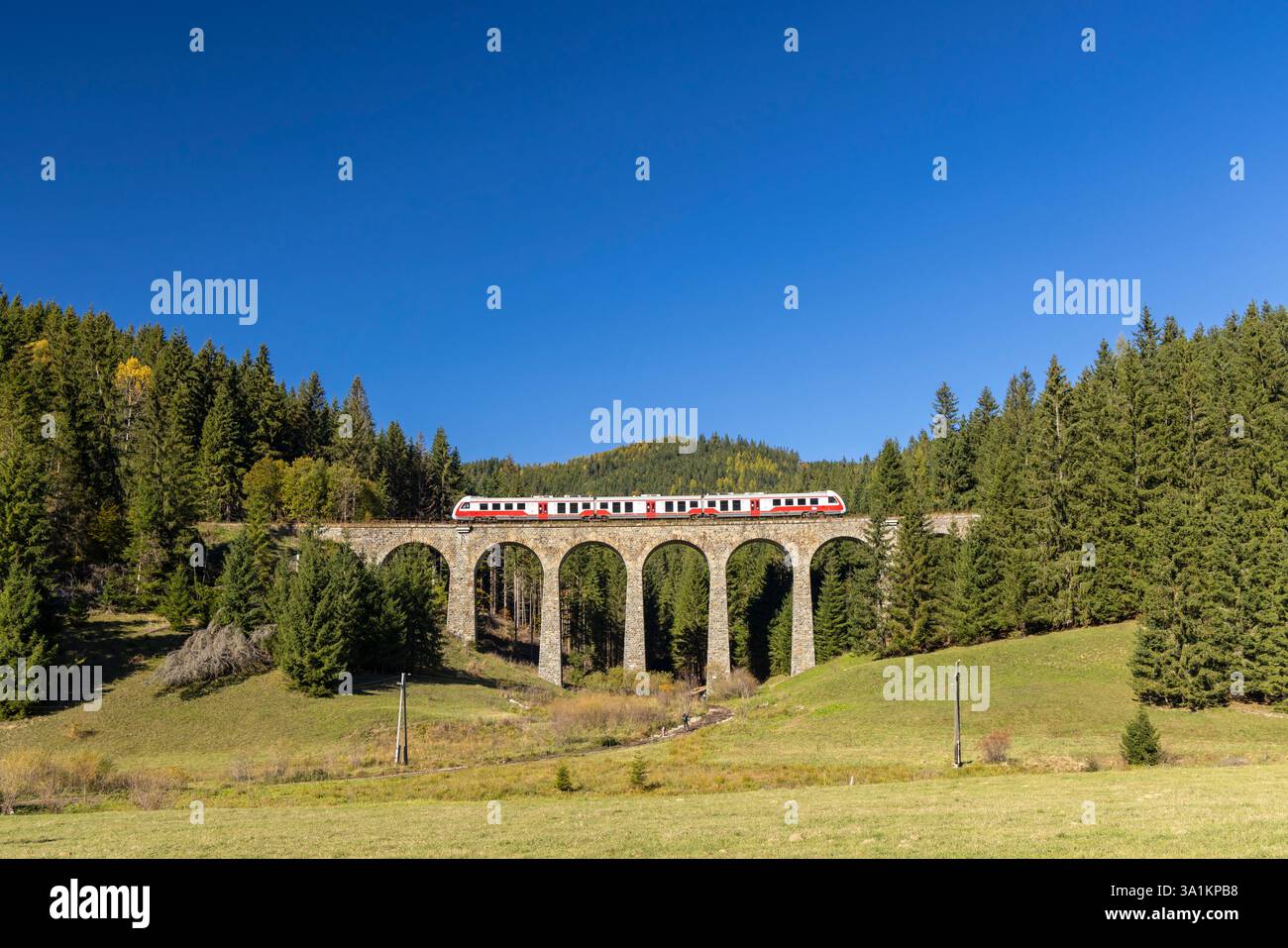 Modern diesel train, railway bridge Chramossky viadukt near Telgart ...
