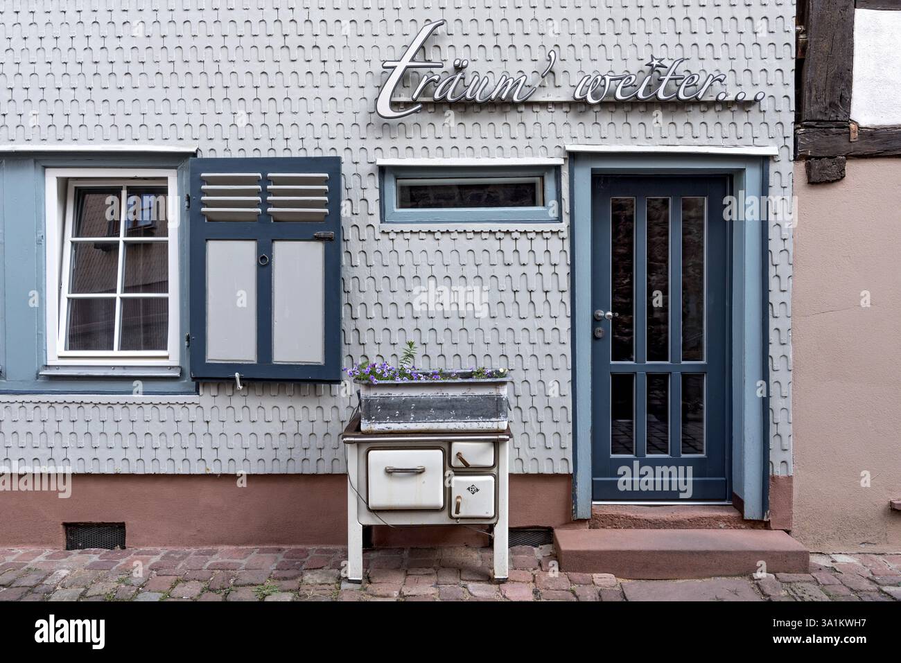 Residential house clad with wooden shingles, old oven for decoration in ...