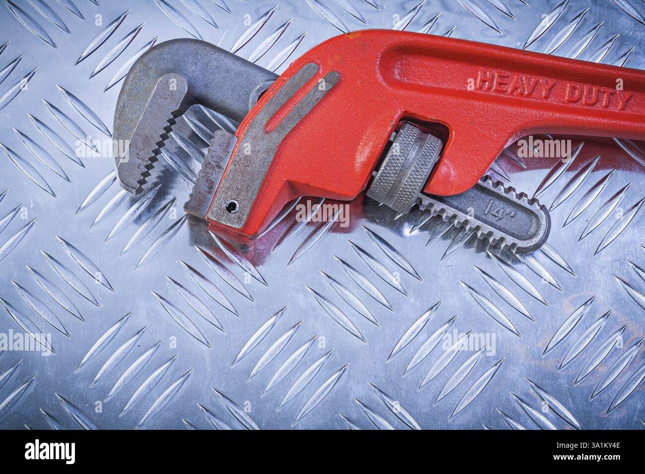 Metal monkey wrench on grooved metallic plate construction concept ...