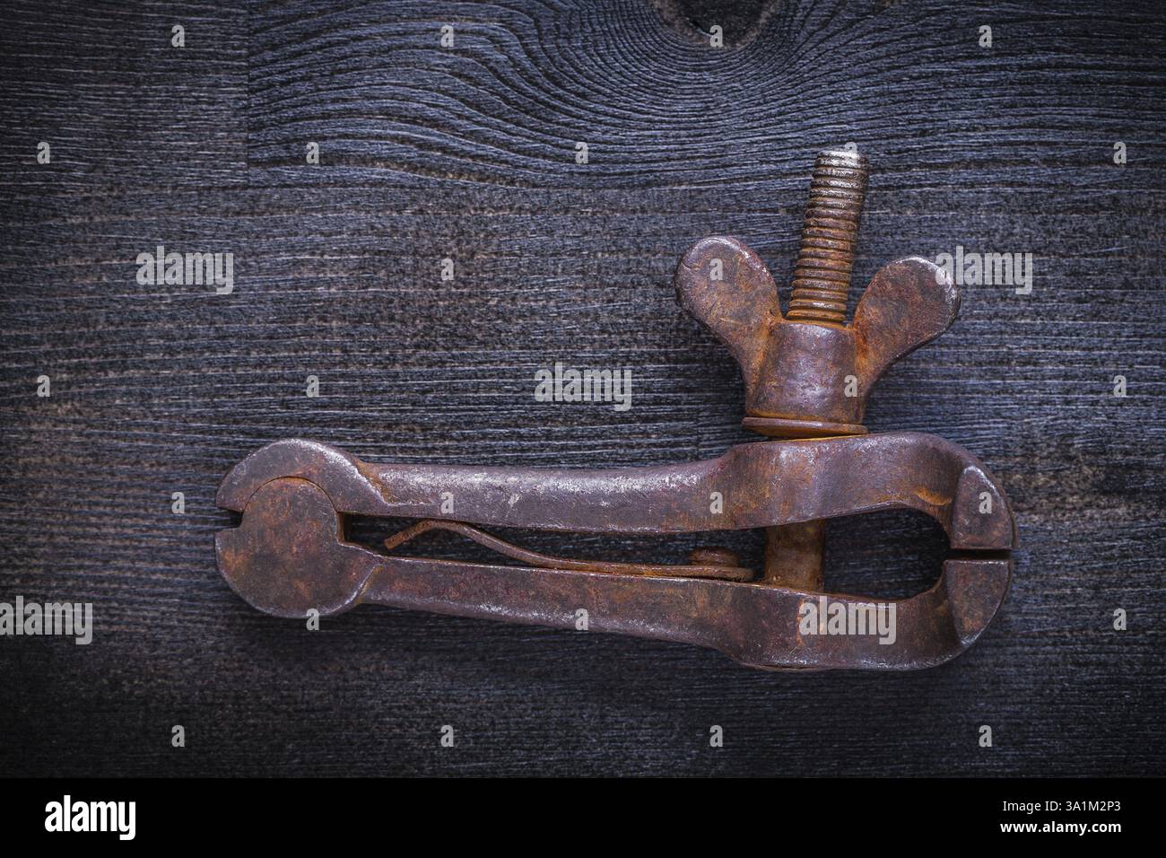 Old clamp on vintage board Stock Photo - Alamy