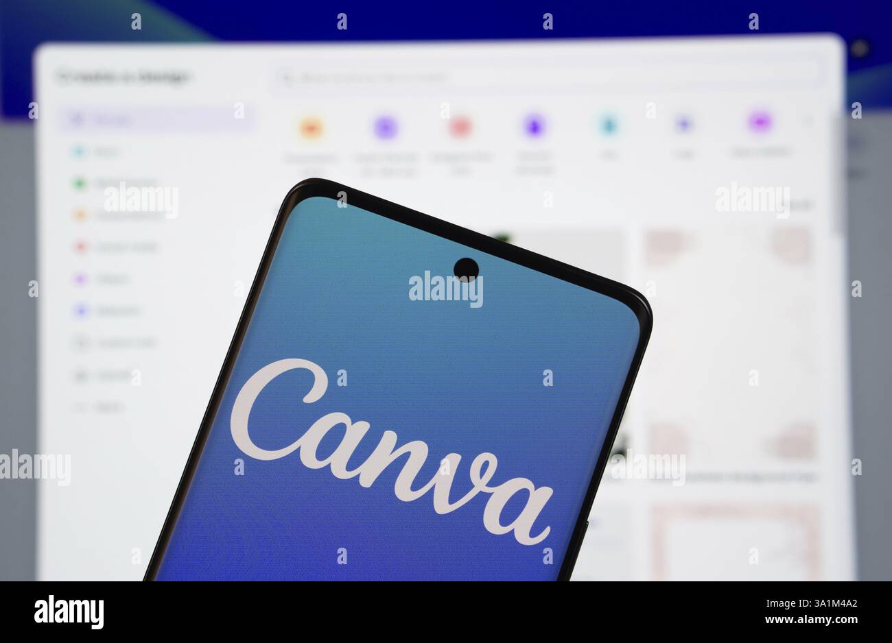 Canva logo is displayed on a smartphone screen, with the canva website ...