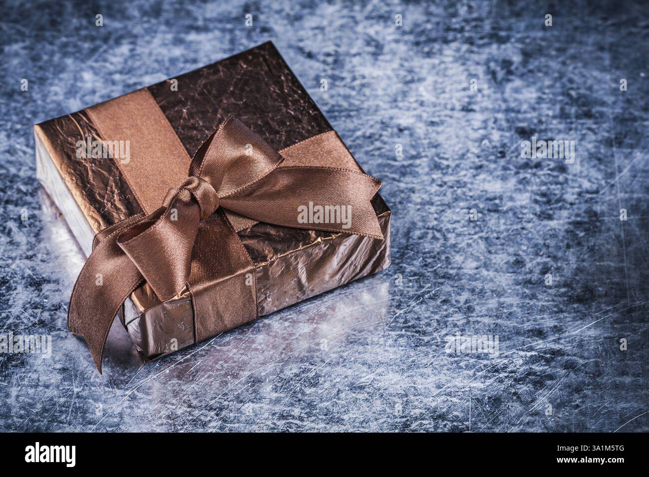Packed present with tied bow on metallic background holiday concept ...