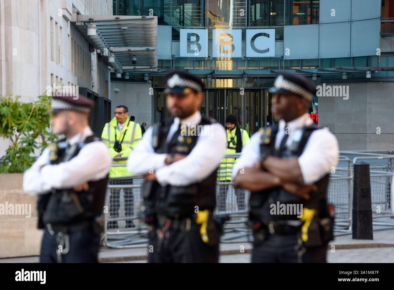 London, UK. 8 March 2025. Three police officers stand guard at the BBC ...