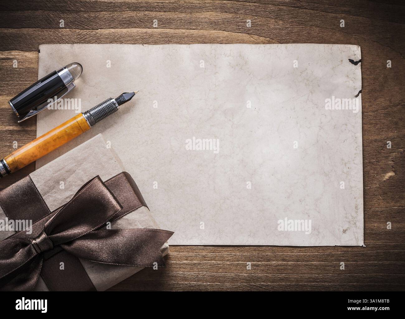 Present box tied ribbon paper fountain pen on wood board Stock Photo ...