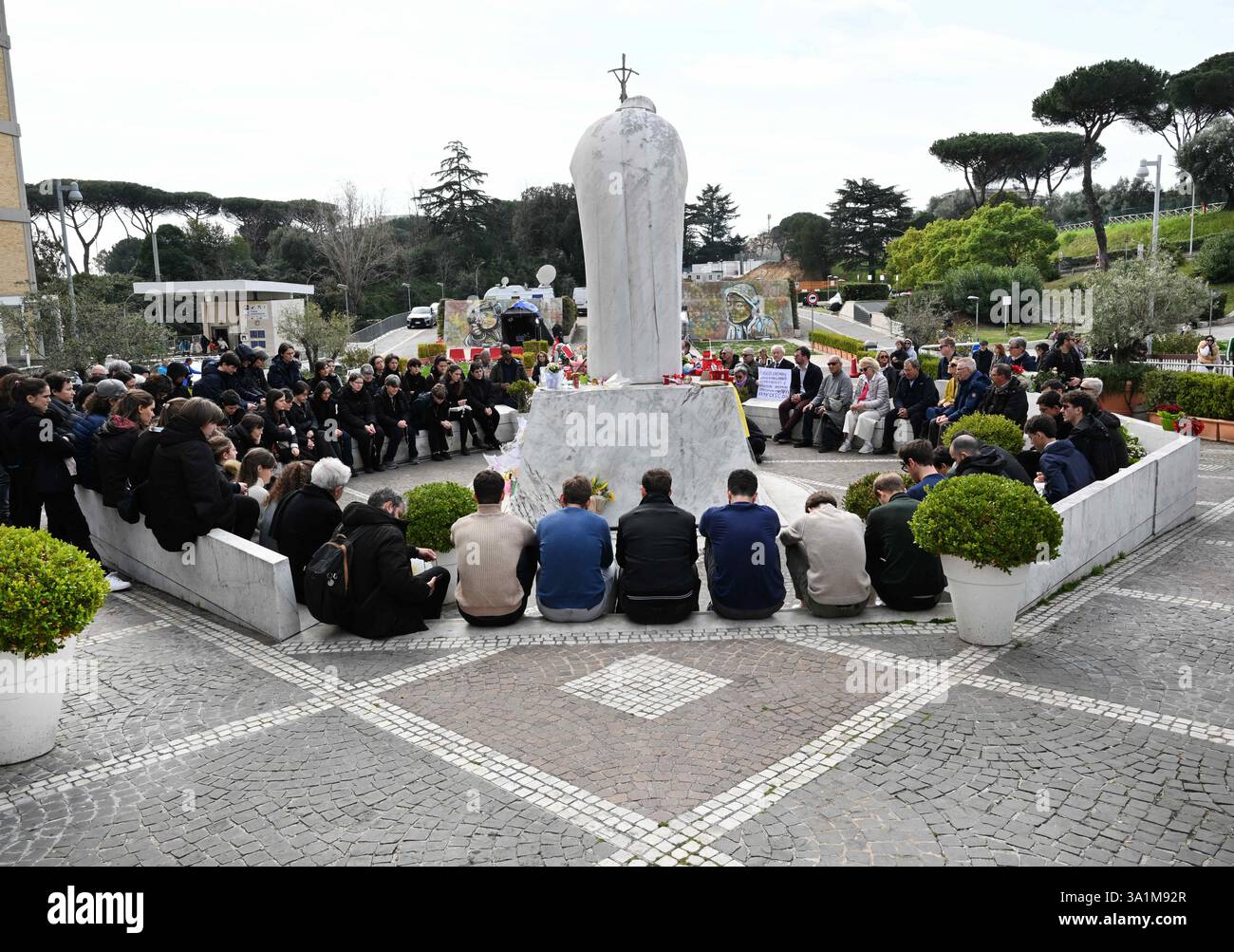 People pray near the statue of John Paul II outside the Gemelli ...