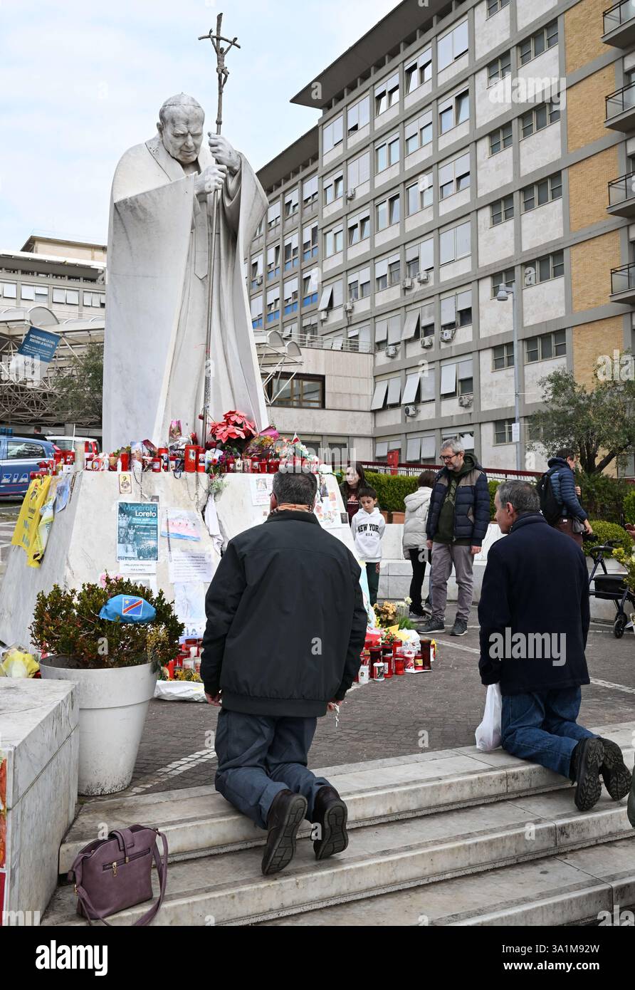 Rome, Italy. 09th Mar, 2025. People pray near the statue of John Paul ...