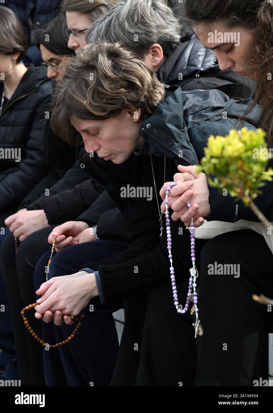 People pray near the statue of John Paul II outside the Gemelli ...