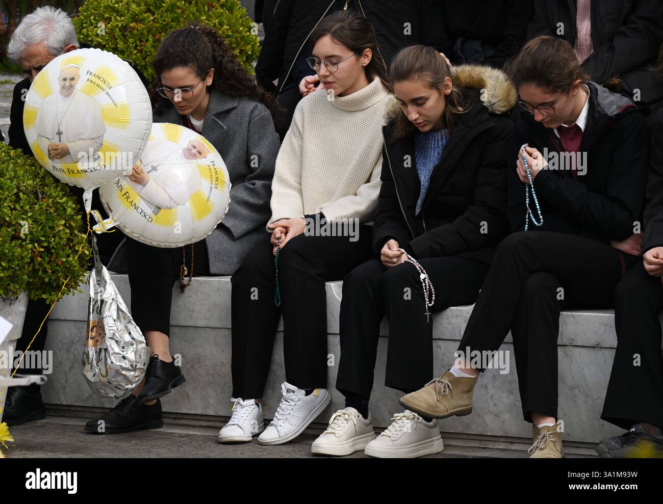 Rome, Italy. 09th Mar, 2025. People pray near the statue of John Paul ...