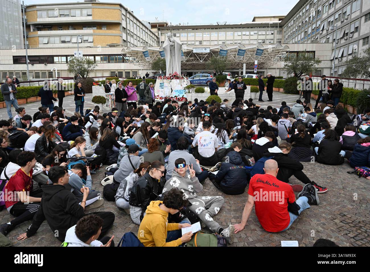 People pray near the statue of John Paul II outside the Gemelli ...